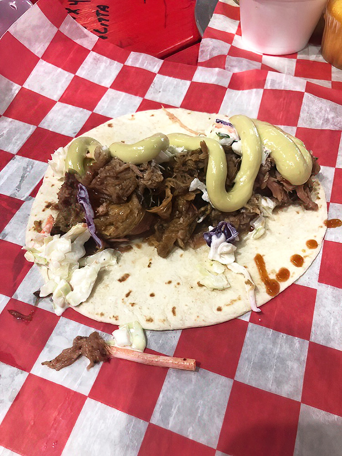 BBQ taco nirvana! Tender smoked meat nestled in a soft tortilla, topped with slaw and that signature green sauce that'll haunt your dreams.