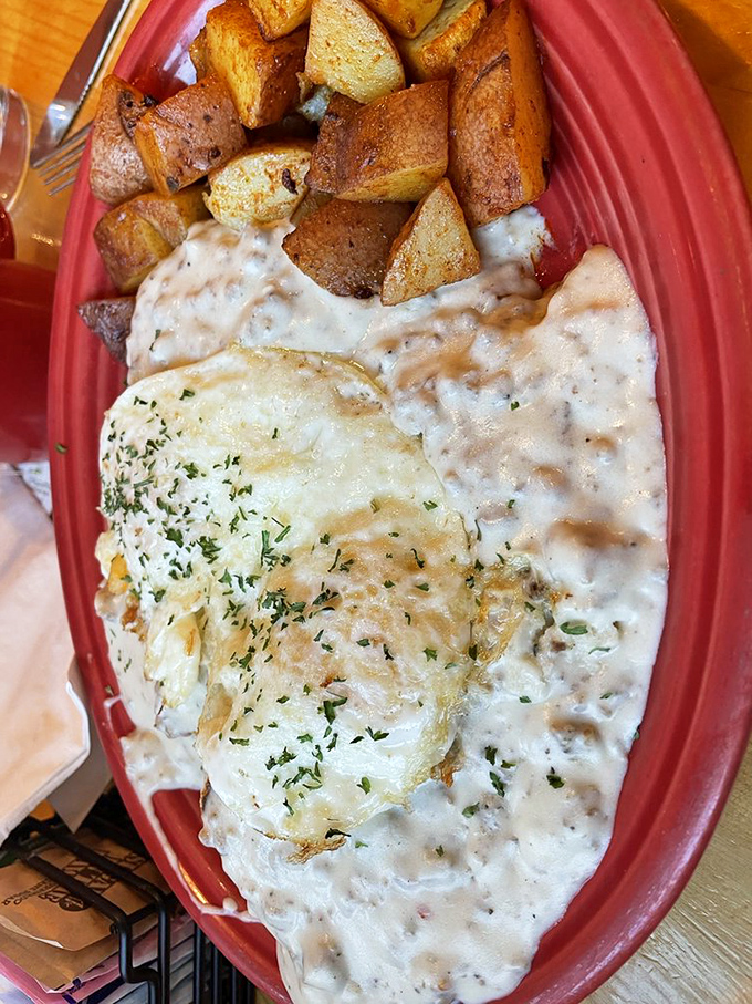 Behold the star attraction: biscuits smothered in homemade pork sausage gravy with eggs and home fries. Diet plans come here to die gloriously.