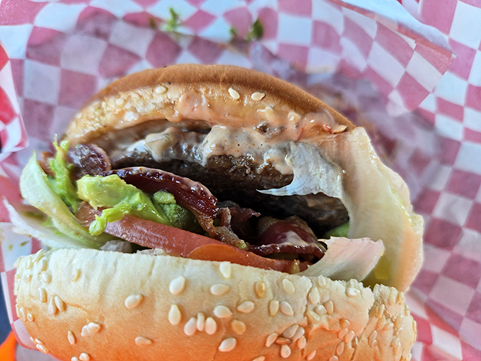 This isn't just a burger; it's architecture. Note how the bacon and fresh veggies create perfect structural integrity around that juicy patty.