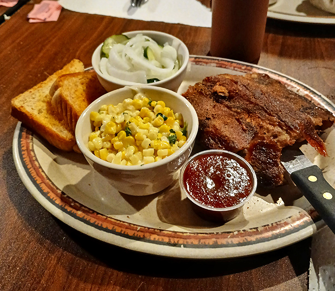 These ribs don't just fall off the bone—they practically leap onto your fork. Served with sweet corn and onions, it's a plate that makes vegetarians question their life choices.