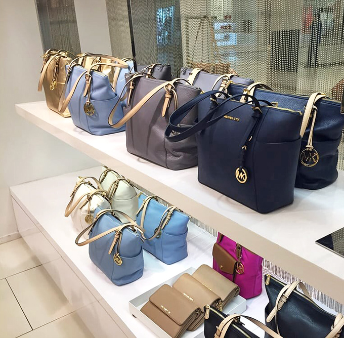Designer handbags lined up like soldiers ready to conquer your credit card statement.