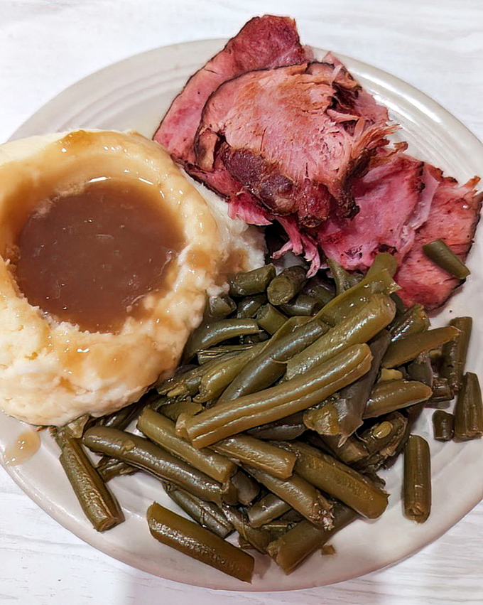 This isn't just baked ham&mdash;it's a masterclass in comfort food geometry: the perfect triangle of meat, the circle of mashed potatoes, the straight lines of green beans.