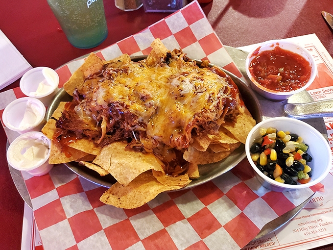 Behold the nachos that launched a thousand return visits: pulled pork, melted cheese, and structural engineering excellence.