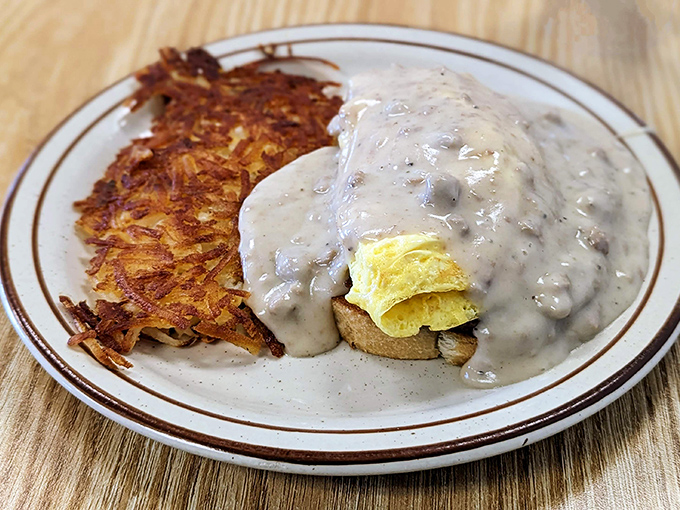 Behold the biscuits and gravy that launched a thousand morning pilgrimages, complete with perfectly crispy hash browns on the side.