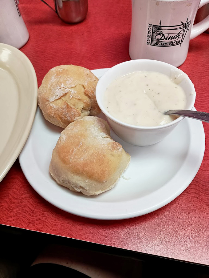 Behold the stars of our show: golden-brown biscuits nestled against creamy pepper-flecked gravy. Simple perfection on a white plate.