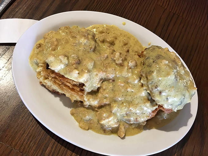 Behold the holy grail of comfort food: biscuits drowning in peppery sausage gravy that would make your Southern grandmother weep with pride.