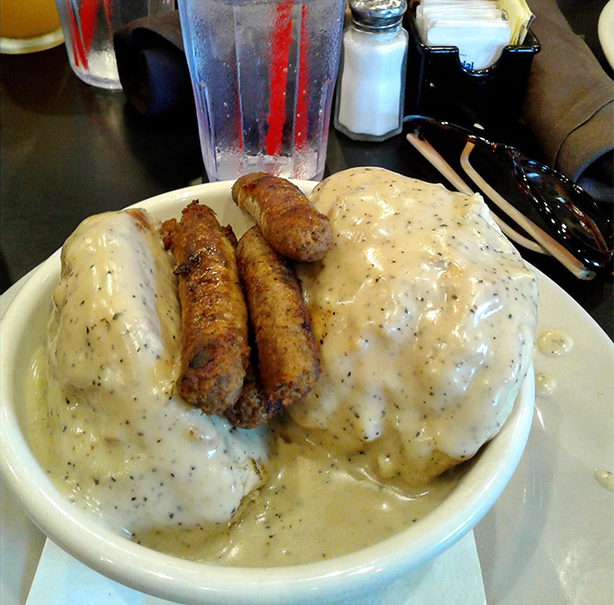 Biscuits drowning in pepper-flecked gravy with sausage links standing guard &ndash; this plate doesn't just feed you, it hugs your soul.