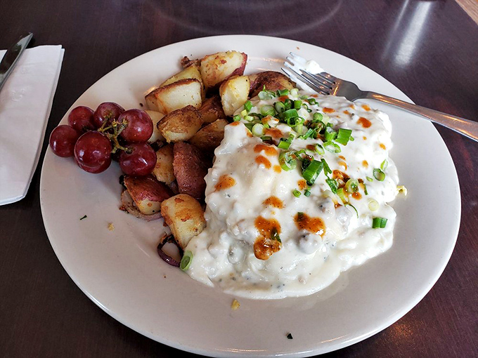 Behold the star attraction: cheddar scallion biscuits smothered in sausage gravy, with perfectly crisp potatoes and grapes providing sweet counterpoint.