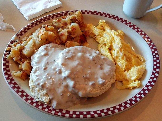 Behold the biscuits and gravy—where a cloud-like biscuit becomes the willing victim of a creamy, peppery gravy avalanche that dreams are made of.