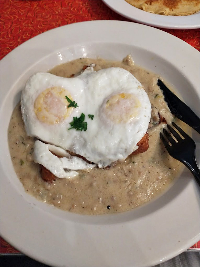 Biscuits and gravy with sunny-side-up eggs form an accidental smiley face. This plate isn't just breakfast &ndash; it's morning therapy.