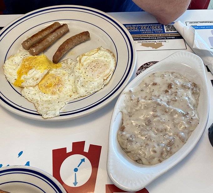 Behold the star attraction &ndash; creamy sausage gravy cascading over fluffy biscuits, with eggs and sausage links playing delicious supporting roles.