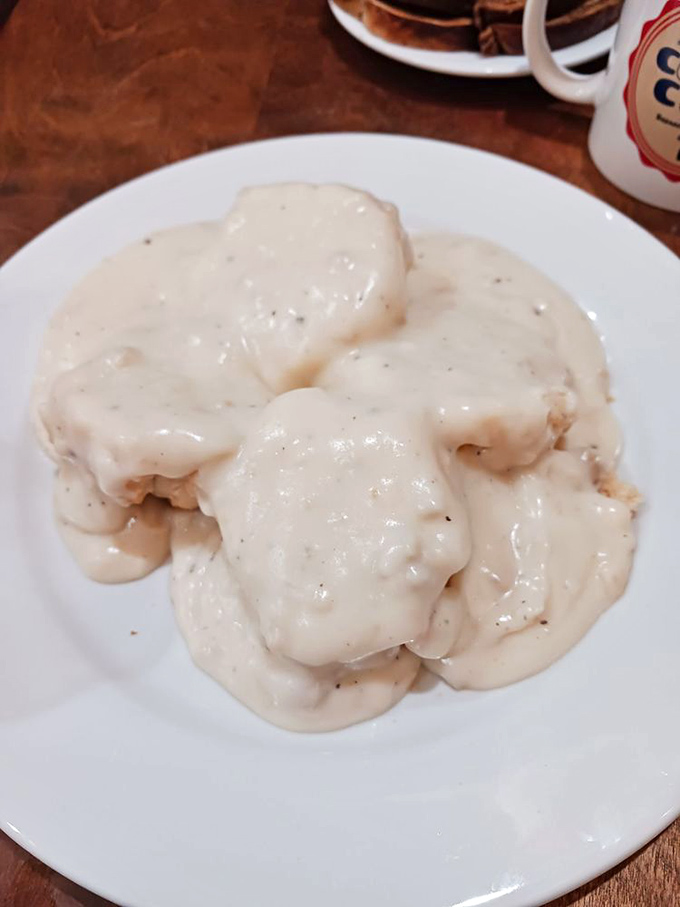 Behold the star attraction—pillowy biscuits swimming in peppery sausage gravy. Poetry on a plate that speaks the universal language of comfort.