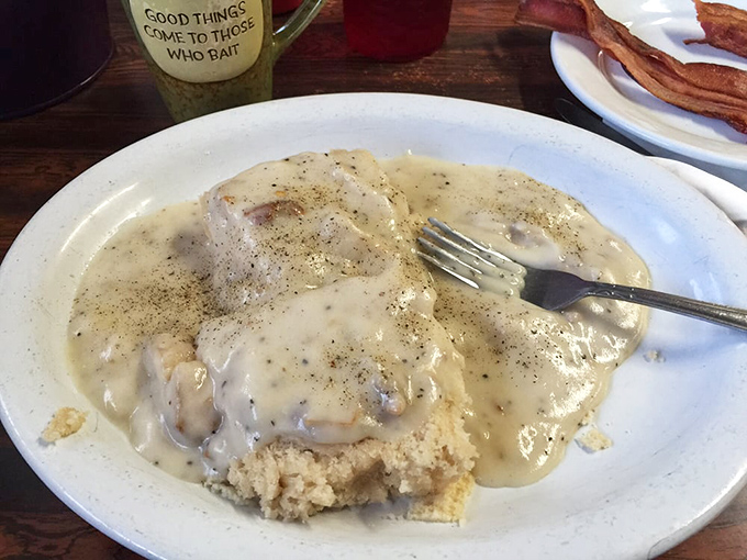 Behold the star attraction: biscuits drowning in perfectly speckled gravy. This isn't just breakfast&mdash;it's edible therapy that makes Monday mornings bearable again.