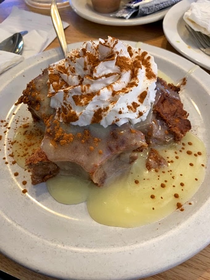 Behold the bread pudding that launched a thousand road trips! Crowned with whipped cream and swimming in vanilla sauce, it's dessert nirvana.