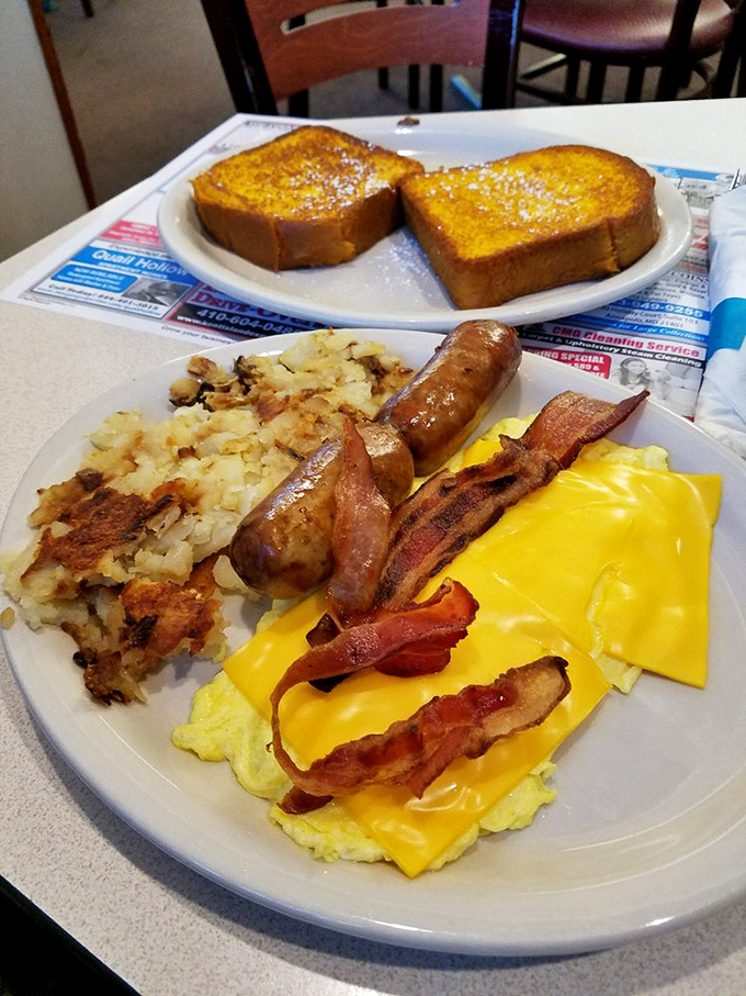 Breakfast nirvana achieved: golden cheese melting over fluffy eggs, crispy home fries, and French toast that makes you question why anyone bothers with fancy brunch. 