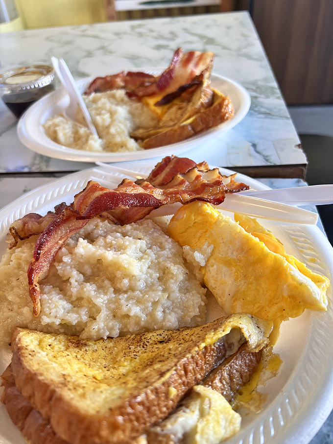 Breakfast nirvana: creamy grits, perfectly folded eggs, crispy bacon, and golden toast &ndash; the four food groups of Southern morning happiness on a single plate.