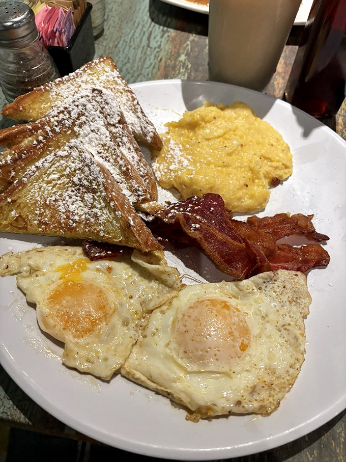 French toast dusted with powdered sugar, perfectly fried eggs, and bacon that knows its job&mdash;this is morning done right.