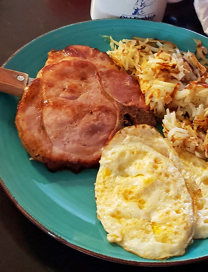 Breakfast perfection on a turquoise plate—crispy ham, golden hash browns, and eggs that would make a rooster proud.