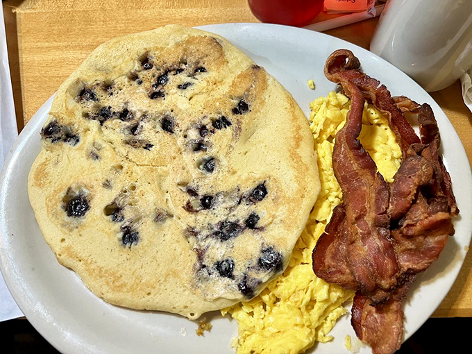 That blueberry pancake is what breakfast dreams are made of&mdash;a fluffy canvas dotted with berries, paired with eggs and bacon that mean business.