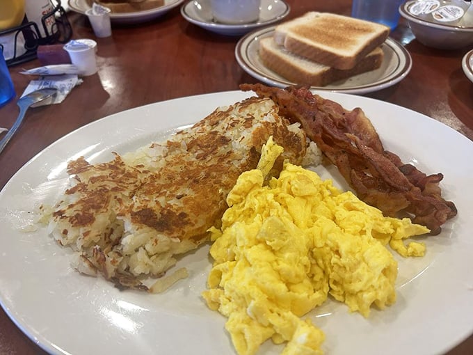 Breakfast perfection on a plate—golden hash browns with that impossible-to-achieve-at-home crust, fluffy scrambled eggs, and bacon cooked to that magical sweet spot.