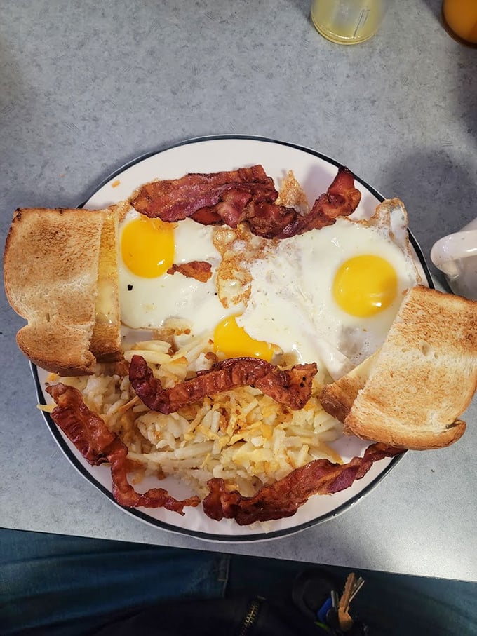 Breakfast nirvana achieved: perfectly sunny-side-up eggs, crispy bacon, and hash browns that have clearly been introduced to a proper griddle.