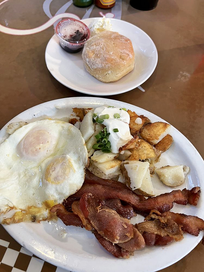 Breakfast of champions! Perfectly cooked eggs, crispy bacon, and potatoes that deserve their own fan club, served with a freshly baked biscuit.