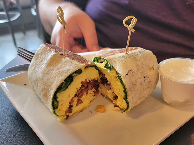 Breakfast rebellion, wrapped in a tortilla. This burrito's cross-section reveals the perfect stratification of morning flavors, held together with melted cheese.