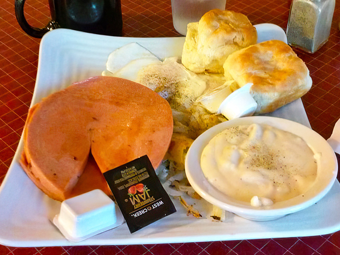 This breakfast platter doesn't just feed your body; it nourishes your soul with golden pancakes and biscuits that could make a Southern grandma weep with pride.