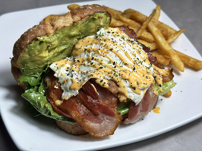 Breakfast architecture at its finest: crispy bacon, perfectly fried eggs, and avocado stacked higher than Florida's humidity.