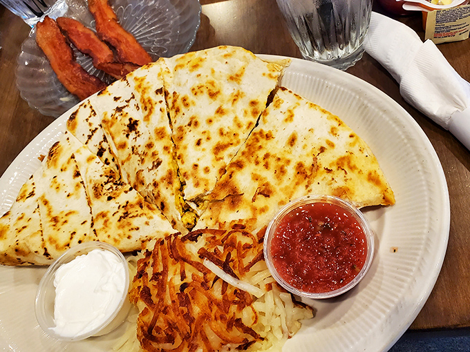 Behold the legendary breakfast quesadilla in its natural habitat&mdash;golden-brown, perfectly sectioned, with salsa and sour cream standing by like faithful companions.