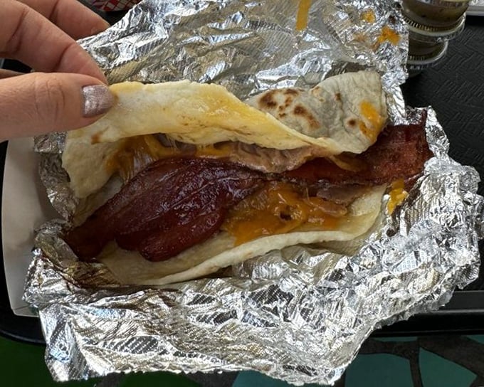 Behold the bacon and egg taco in all its foil-wrapped glory. That tortilla isn't just holding ingredients; it's cradling breakfast perfection.