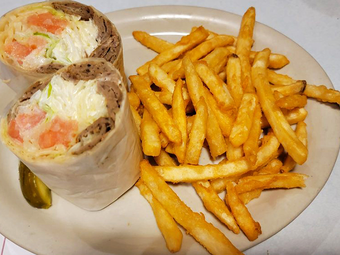 Behold the breakfast wrap in all its glory &ndash; eggs, cheese, and veggies bundled like precious cargo in a tortilla, with those golden fries standing at attention.