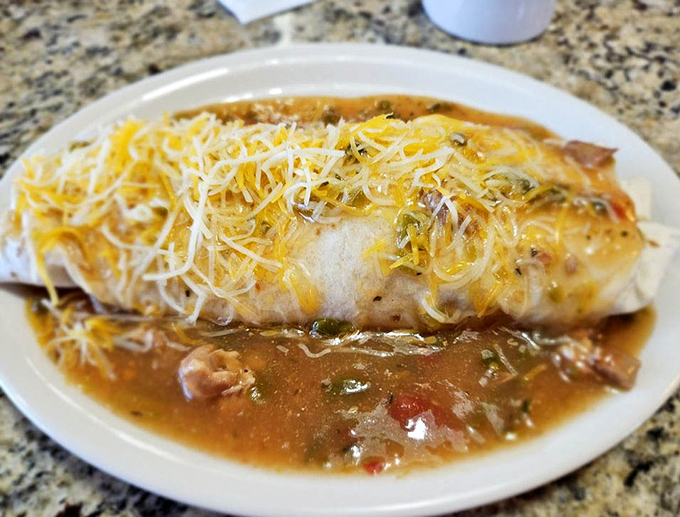 Behold the breakfast burrito in its natural habitat: smothered in green chili and cheese, waiting to solve all your morning problems.