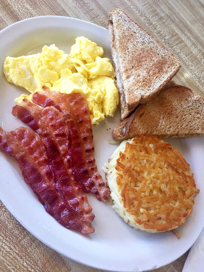 Breakfast perfection on a plate: fluffy scrambled eggs, crispy bacon, golden hash browns, and toast. Simple pleasures that never go out of style.