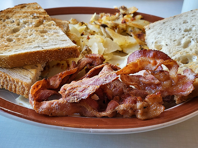 Crispy bacon that shatters like glass, golden home fries, and toast that's actually buttered properly&mdash;breakfast fundamentals executed with respect.