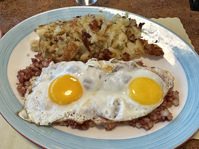 Sunny-side up eggs perched atop a mountain of corned beef hash—proof that sometimes the best views in Virginia aren't from the Blue Ridge Mountains.