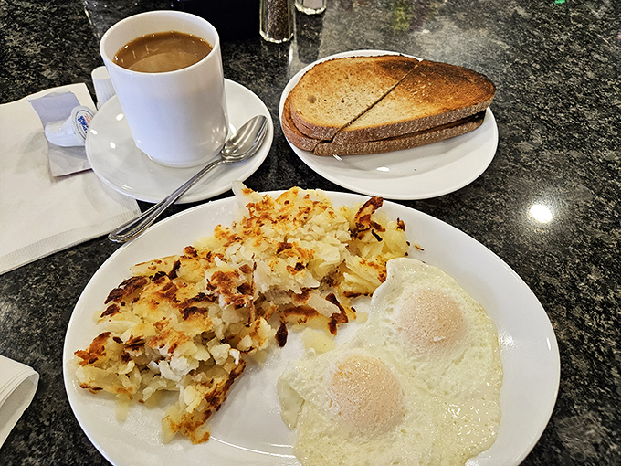 Breakfast perfection on a plate: crispy hash browns, eggs with just-right whites, and toast waiting for its butter bath.
