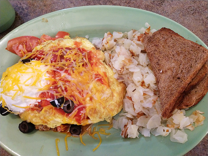 This isn't just an omelet&mdash;it's a morning masterpiece where cheese cascades over perfectly folded eggs, with home fries that deserve their own fan club.