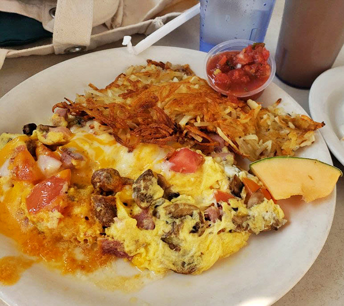This isn't just an omelet &ndash; it's a masterpiece of morning engineering with perfectly crisped hash browns that make you question all other potato preparations.