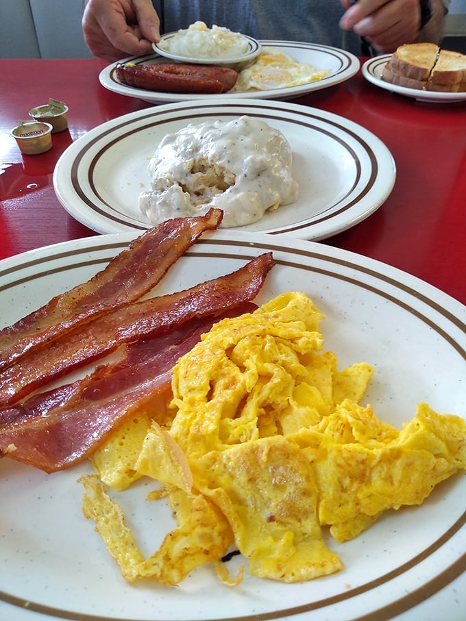 Breakfast perfection on a plate: scrambled eggs with the color of sunshine and bacon crisped to that magical point between chewy and crunchy.