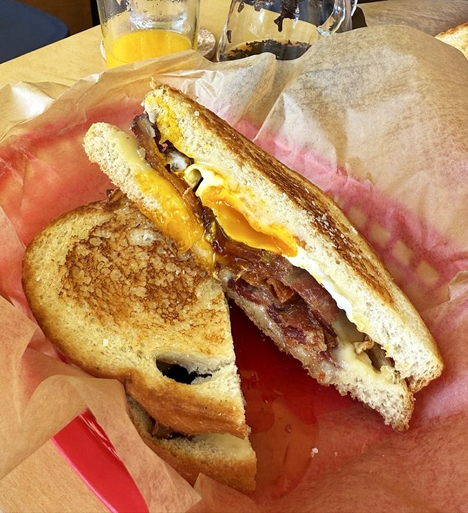 Breakfast sandwich nirvana achieved! Golden toasted sourdough embraces melty cheese, perfectly cooked bacon, and that glorious runny egg that makes life worth living.