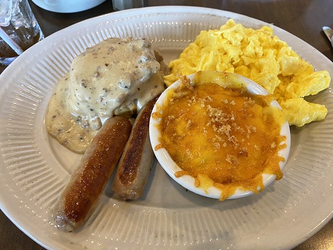 Breakfast perfection on a plate: golden scrambled eggs, savory sausage links, and what appears to be a heavenly cheese-topped side dish.