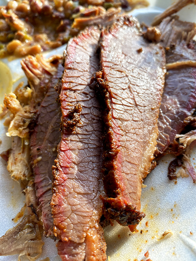 Behold the holy grail of barbecue – brisket with that perfect pink smoke ring that whispers, "I've been pampered for hours."