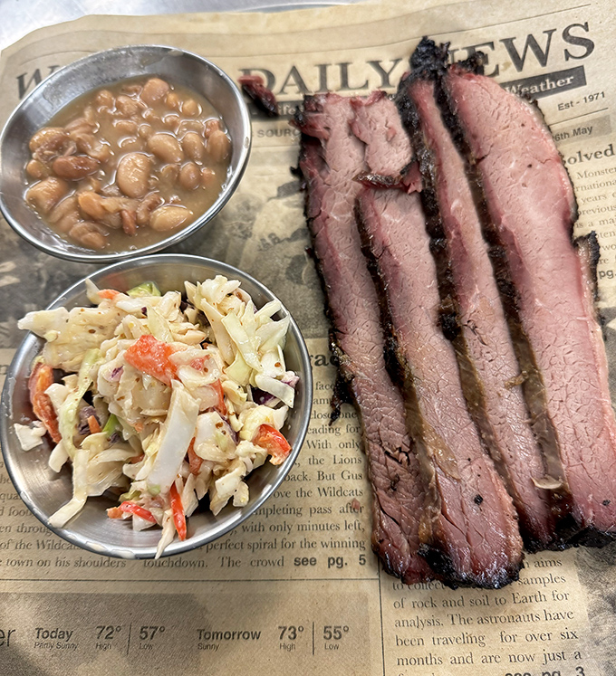 Brisket with that perfect pink smoke ring served on newspaper&mdash;because when meat's this good, fancy plates would just be showing off.