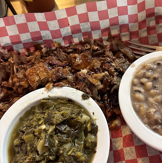 This isn't just a plate&mdash;it's a BBQ trinity: tender chopped meat, collard greens swimming in pot liquor, and beans that have clearly been introduced to pork.