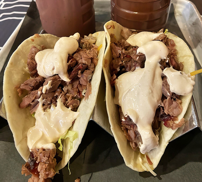 Behold the famous brisket tacos in all their glory. The sauce cascading down like a waterfall of flavor is not an accident&mdash;it's BBQ destiny.