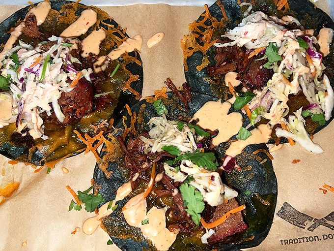 Blue corn tortillas cradle smoky brisket like they were made for each other, topped with slaw and sauce that'll make you question all other tacos.