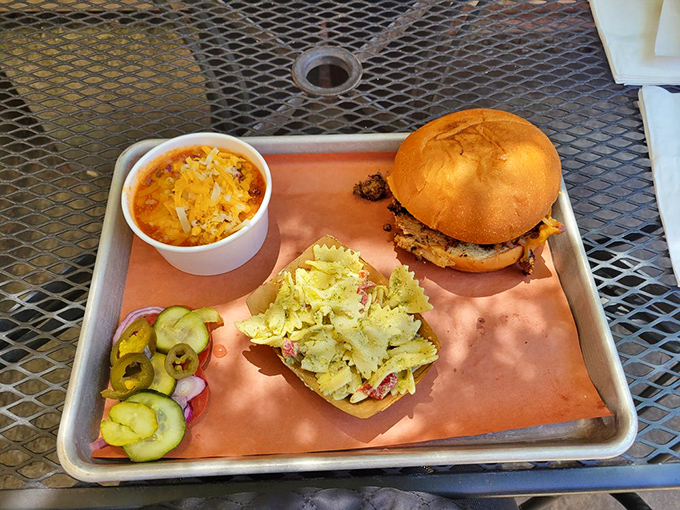 The holy trinity of BBQ perfection: a sandwich that demands two hands, mac and cheese that's actually cheesy, and house-made pickles for that zingy contrast.