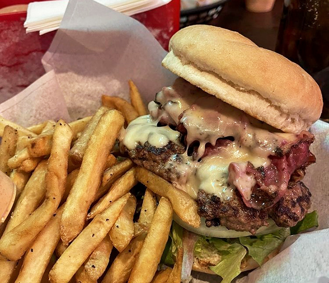 This isn't just a burger &ndash; it's architecture. Melted cheese cascades over perfectly charred beef with hand-cut fries standing at attention nearby.
