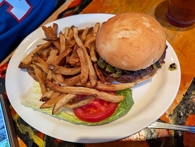 The burger arrives like a savory monument to simplicity done right&mdash;hand-cut fries standing guard beside the star attraction.